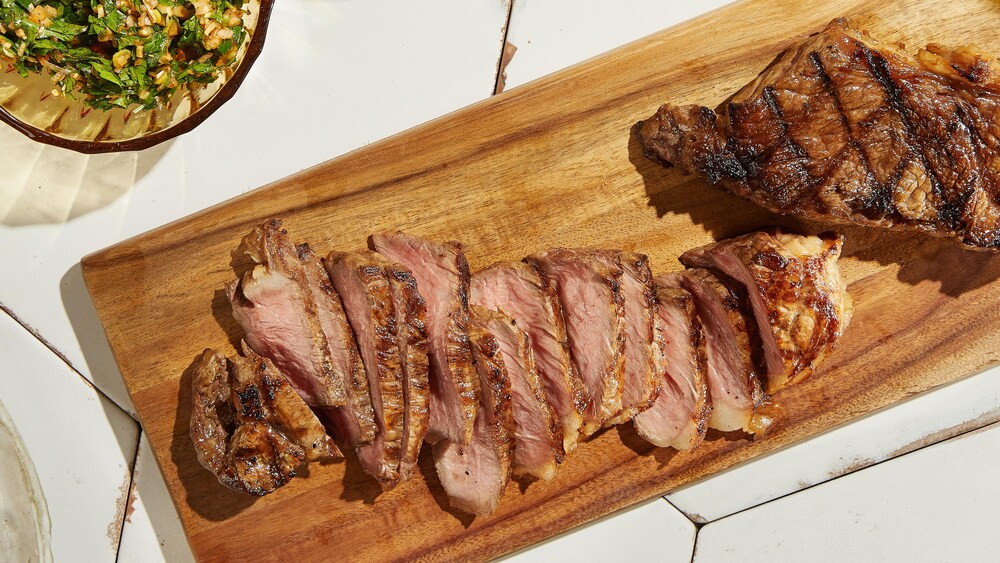 Un contrefilet de bœuf tranché sur une planche de bois.