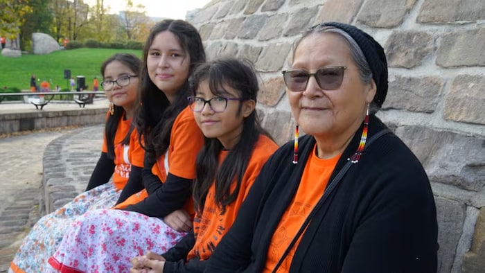 « Chaque enfant compte », insiste Wab Kinew à une foule portant des ...