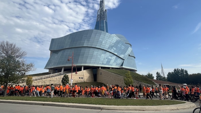 « Chaque enfant compte », insiste Wab Kinew à une foule portant des ...