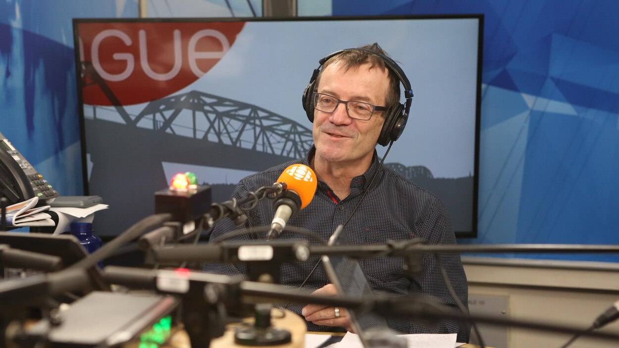 Jean-Pierre Girard accroche son micro | Radio-Canada